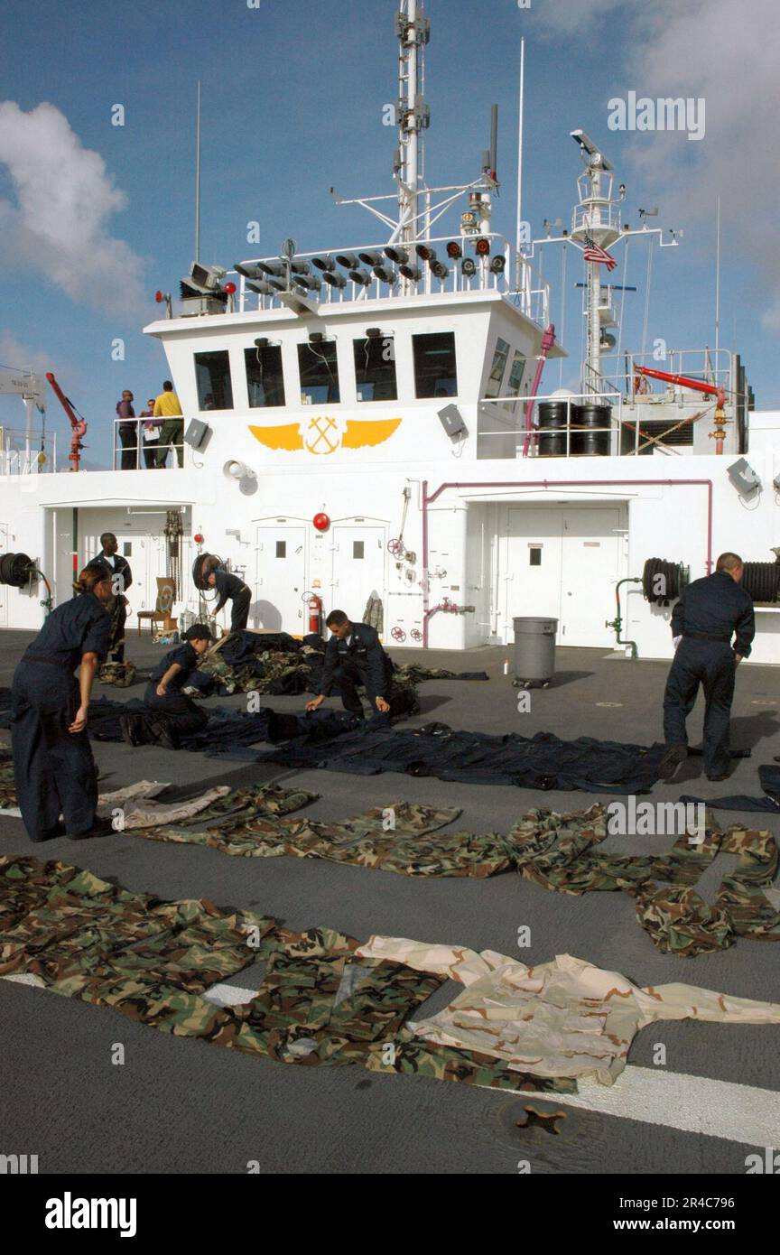 US Navy Crew members prepare uniforms to be sprayed with Permethrin on ...