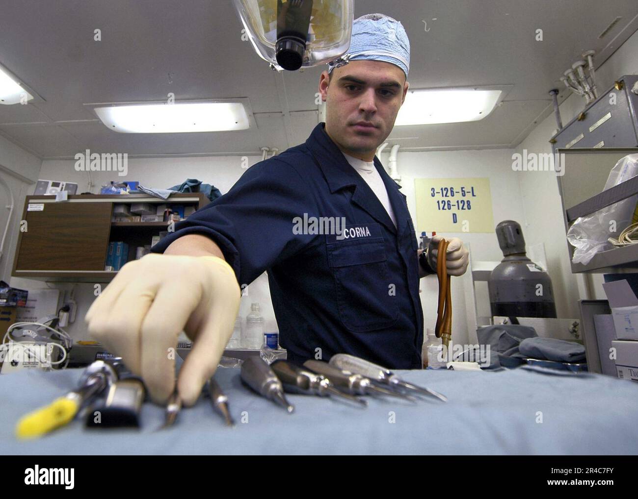 US Navy Hospital Corpsman sets up dental tools for a tooth extraction ...
