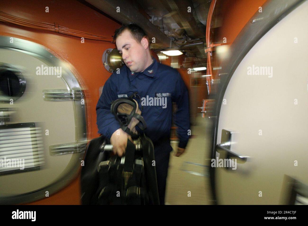US Navy Electronics Technician 3rd Class carries an oxygen breathing ...