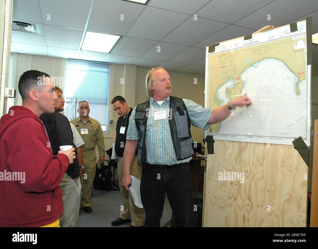US Navy Operations Section Chief gives situational updates using a map ...