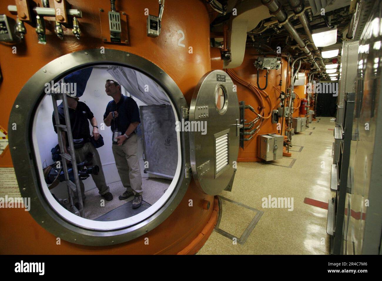 US Navy Members of the media film inside a lock out chamber aboard the ...