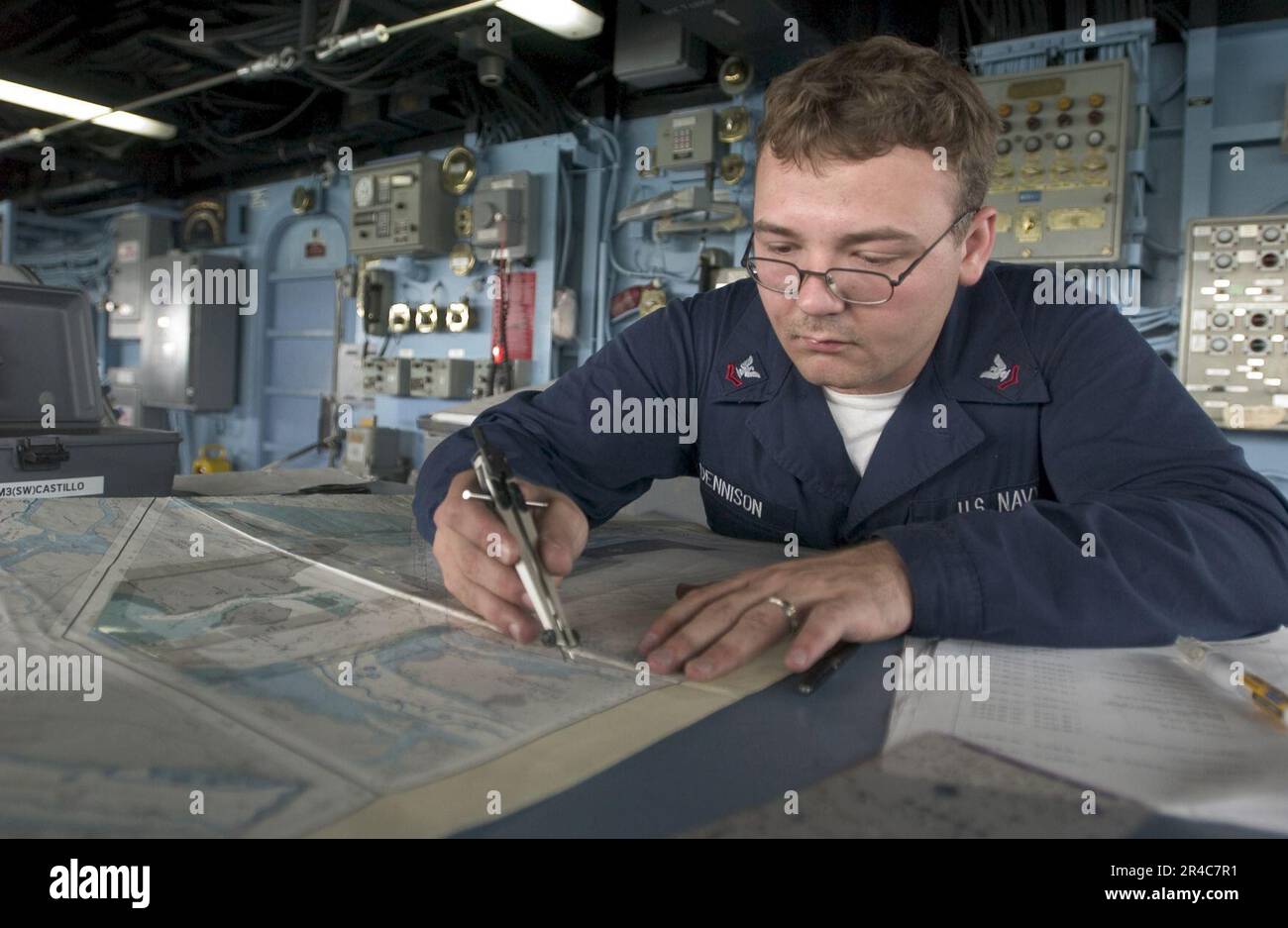 US Navy Quartermaster 2nd Class prepares a navigation chart on the ...