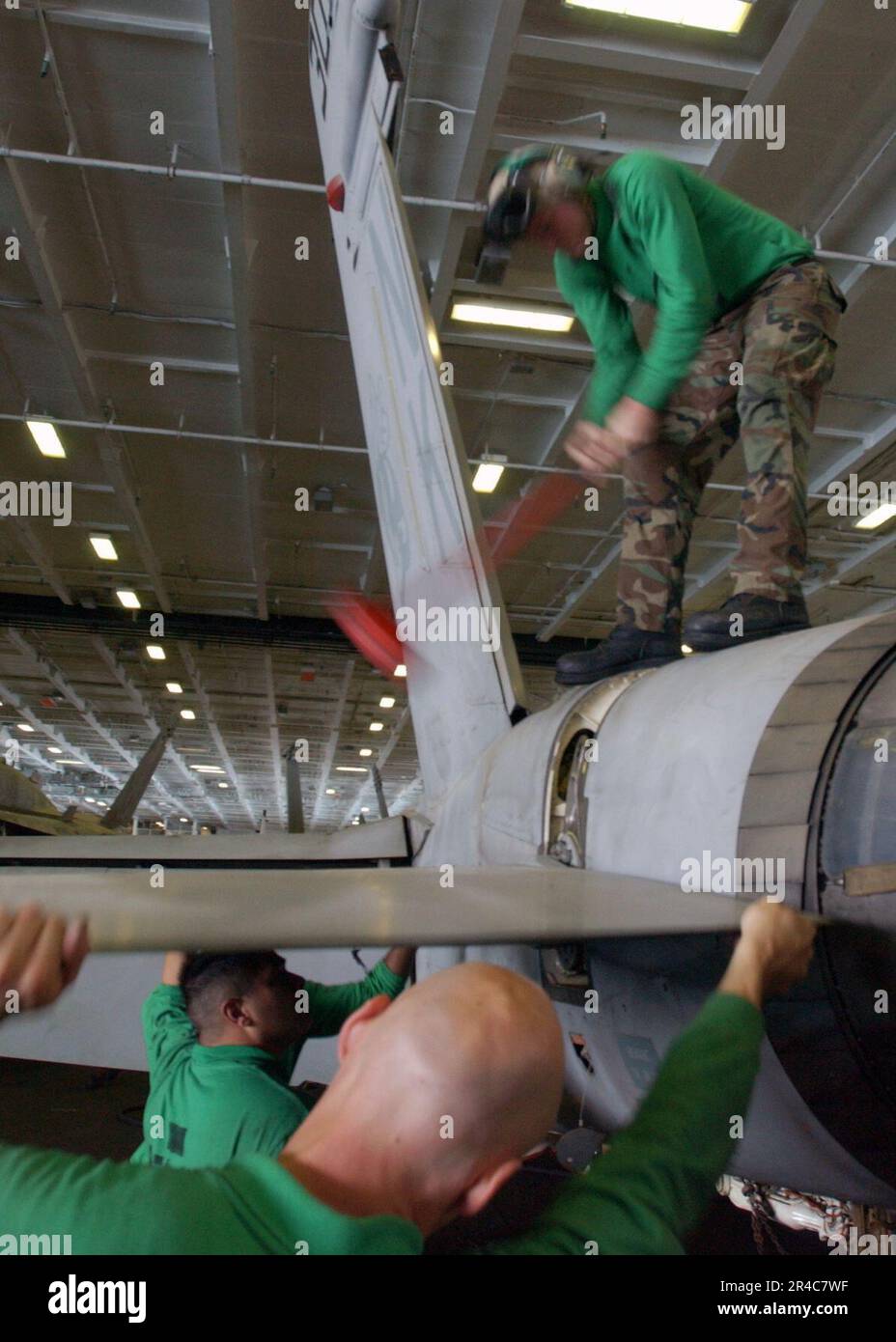 US Navy Sailors from VFA-113 position left horizontal stabilizer of an ...