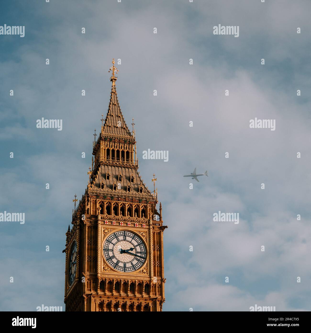 Aerial view of a tall modern tower against a cloudy blue sky, with an ...