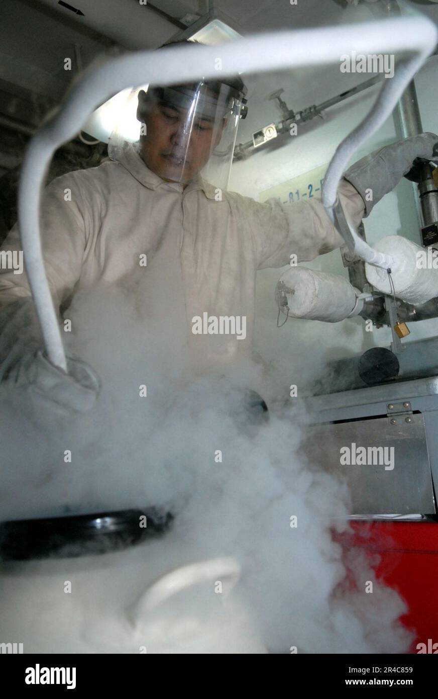US Navy Machinist's Mate 2nd Class fills a dewars tank with liquid ...