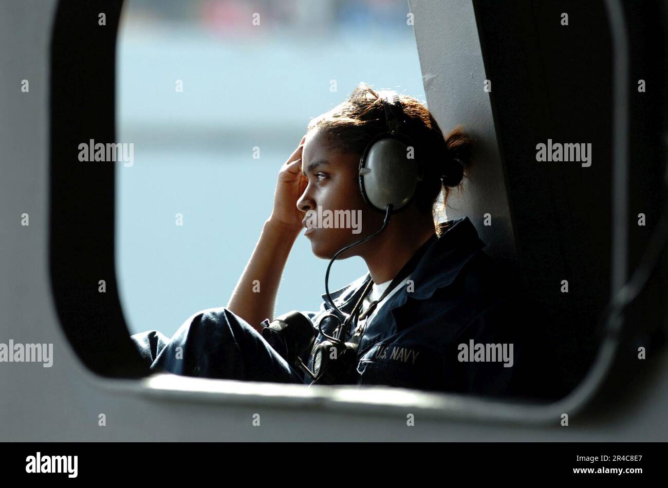 US Navy Seaman stands watch observing the transfer of cargo, supplies ...