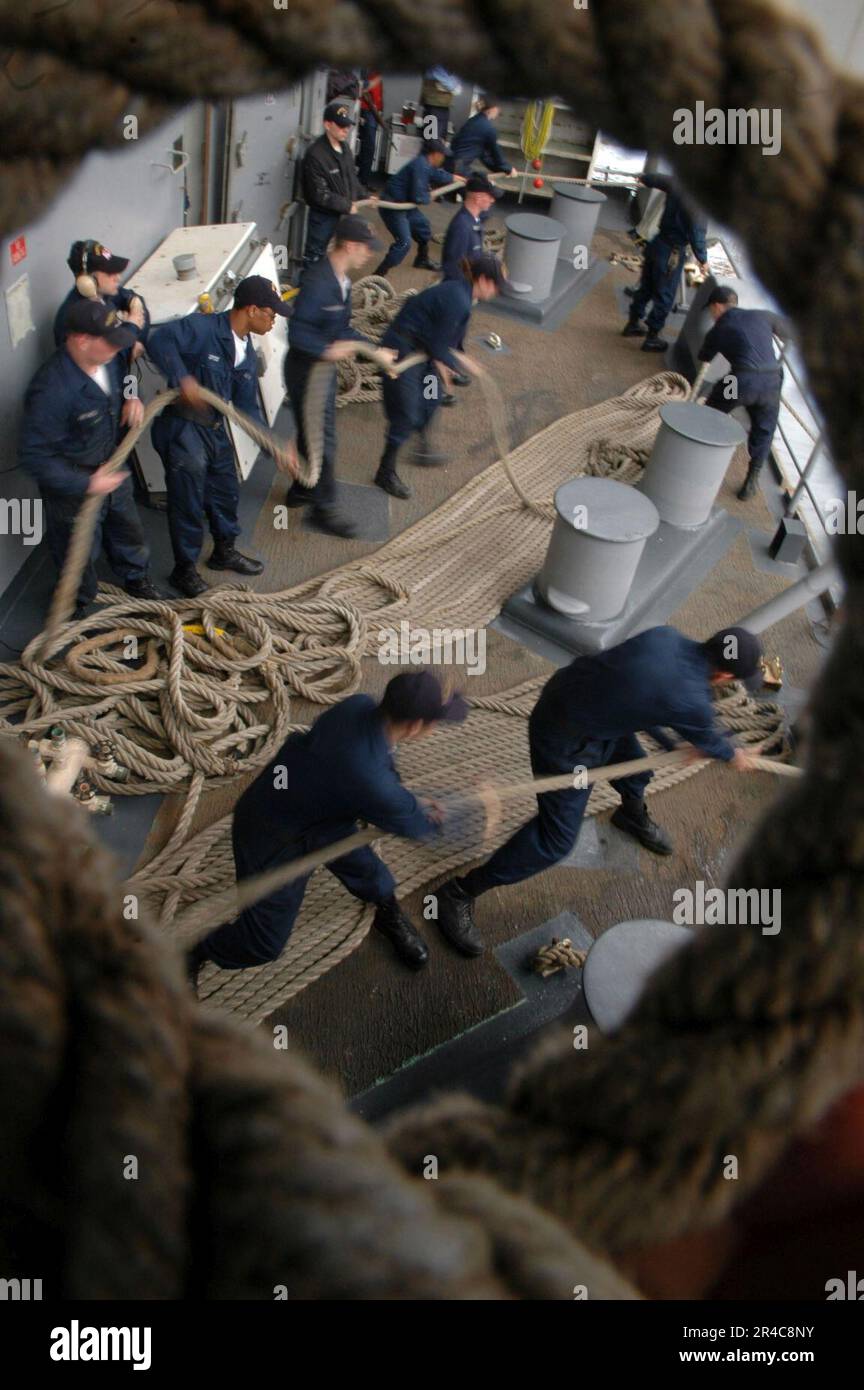 US Navy Deck Department Sailors heave on mooring lines as USS Kitty ...