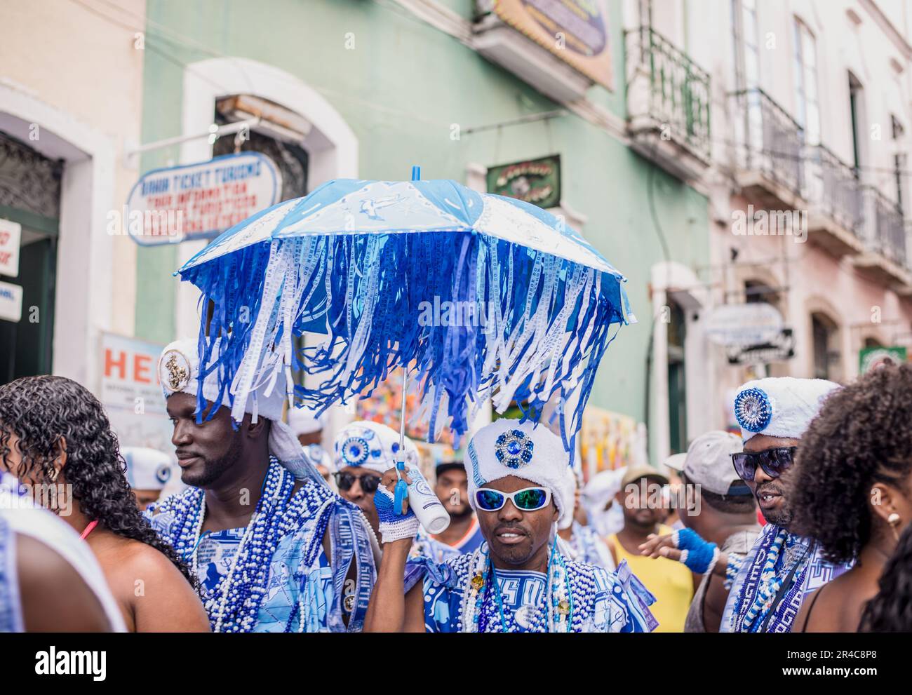 A diverse group of people joyfully marching in a parade, with blue ...