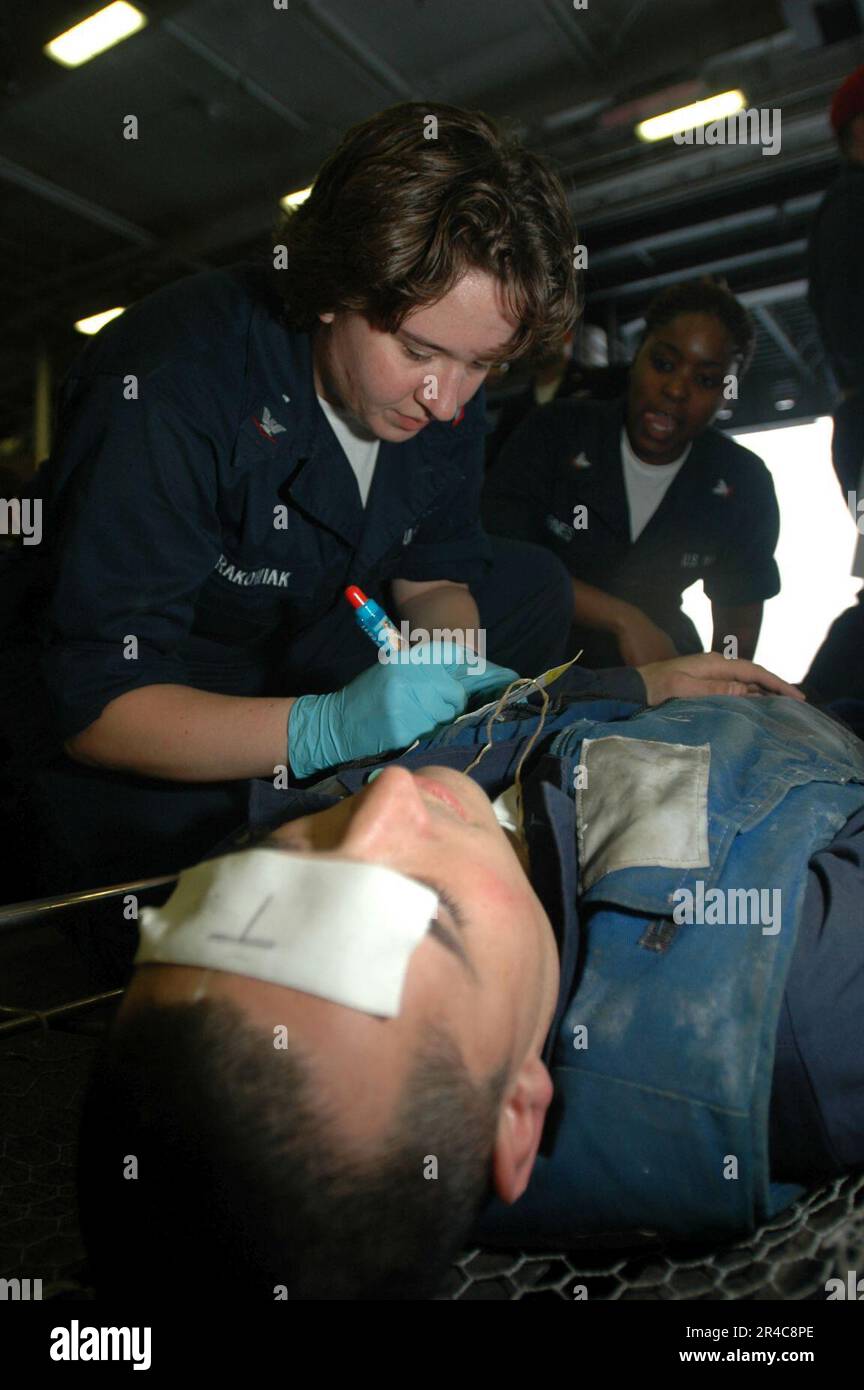 US Navy Hospital Corpsman 3rd Class provides medical attention to a ...