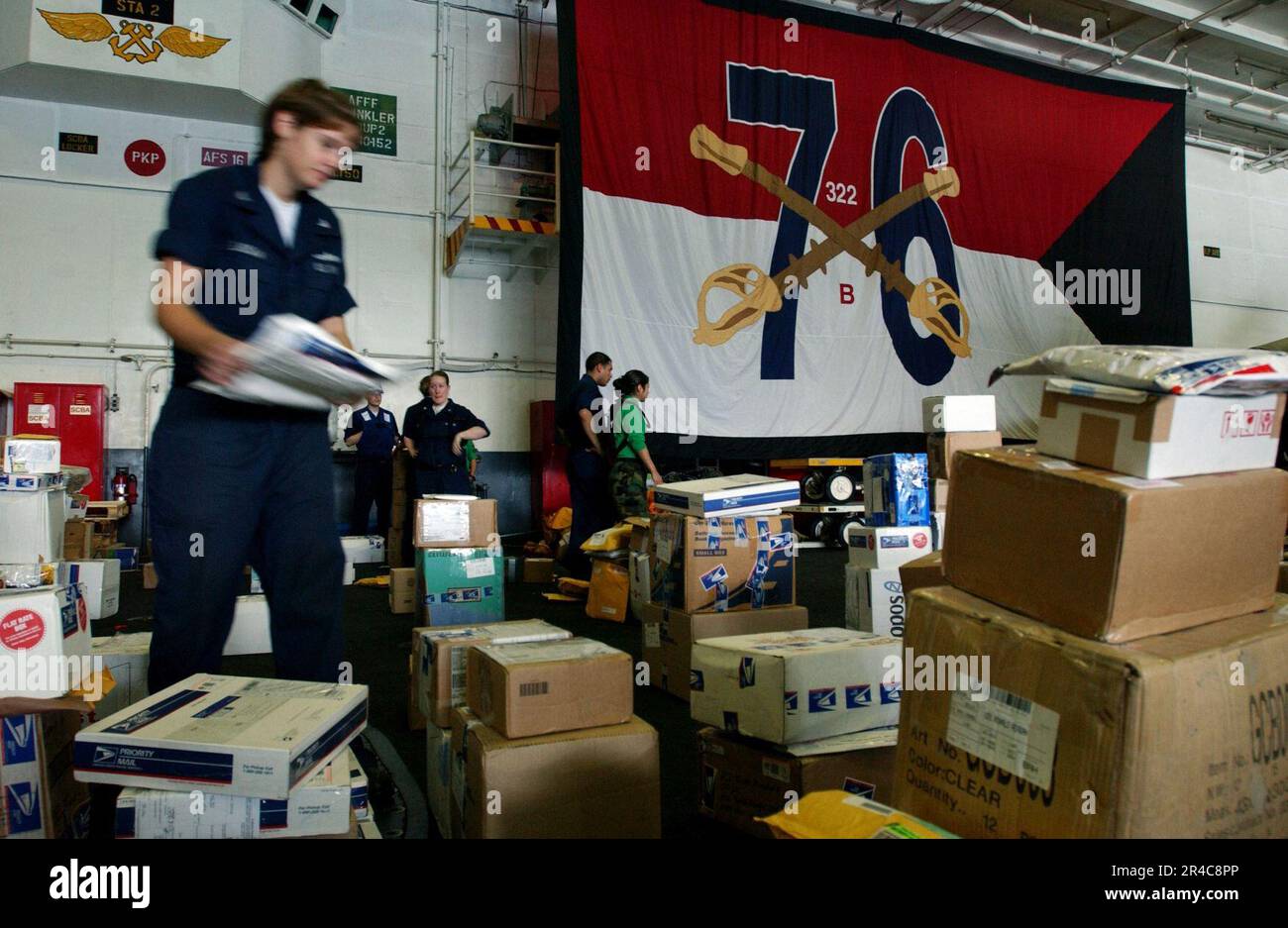 US Navy Postal Clerk 3rd Class separates mail on the hangar bay floor ...