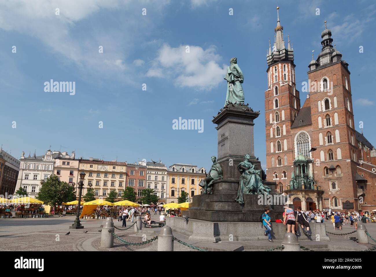 People walking in main square in Krakow, Poland, with Towers of St ...