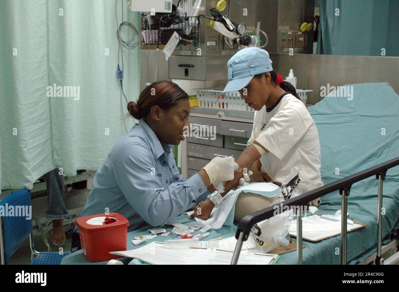 US Navy Hospital Corpsman draws blood from a patient in the casualty ...