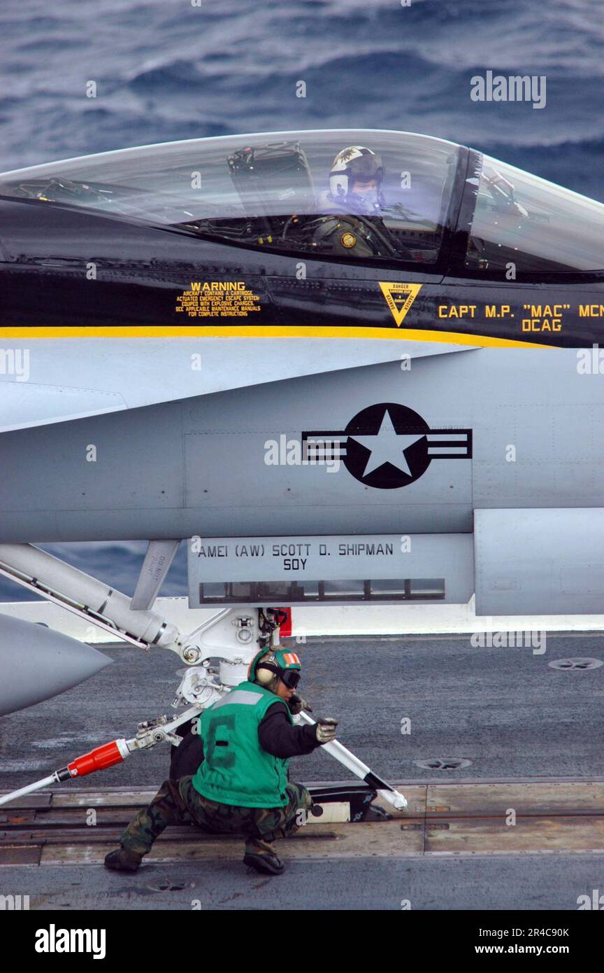 US Navy A flight deck Sailor makes preparations to launch an F-A-18E ...