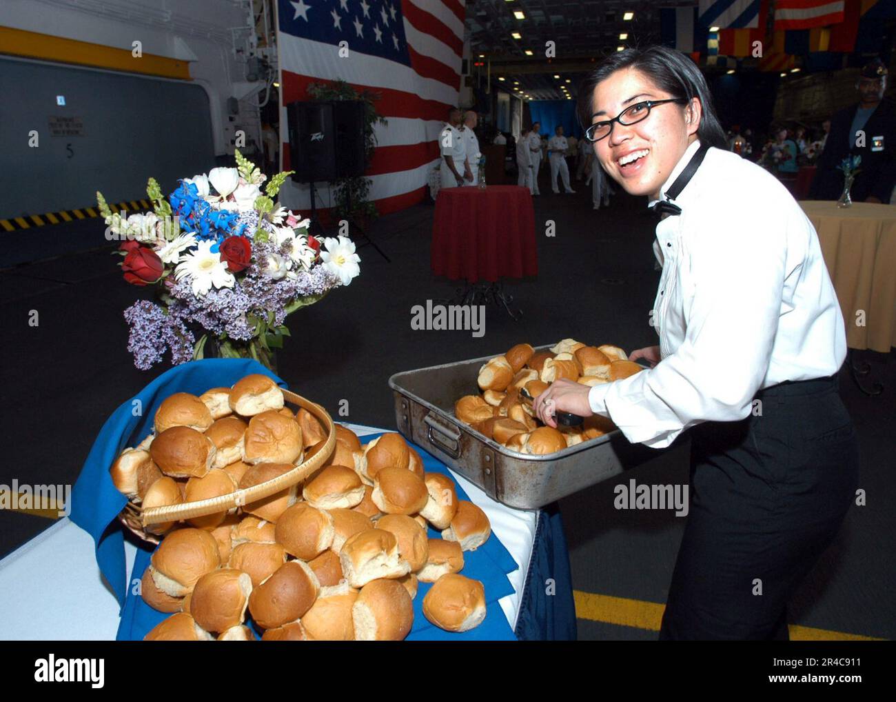 US Navy Culinary Specialist 3rd Class places fresh rolls on one of the ...