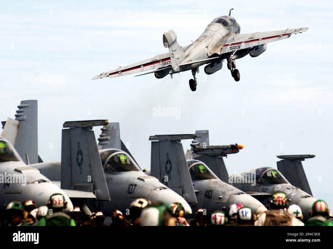 US Navy Over a row of F-A-18 Hornets an EA-6B Prowler assigned to the ...