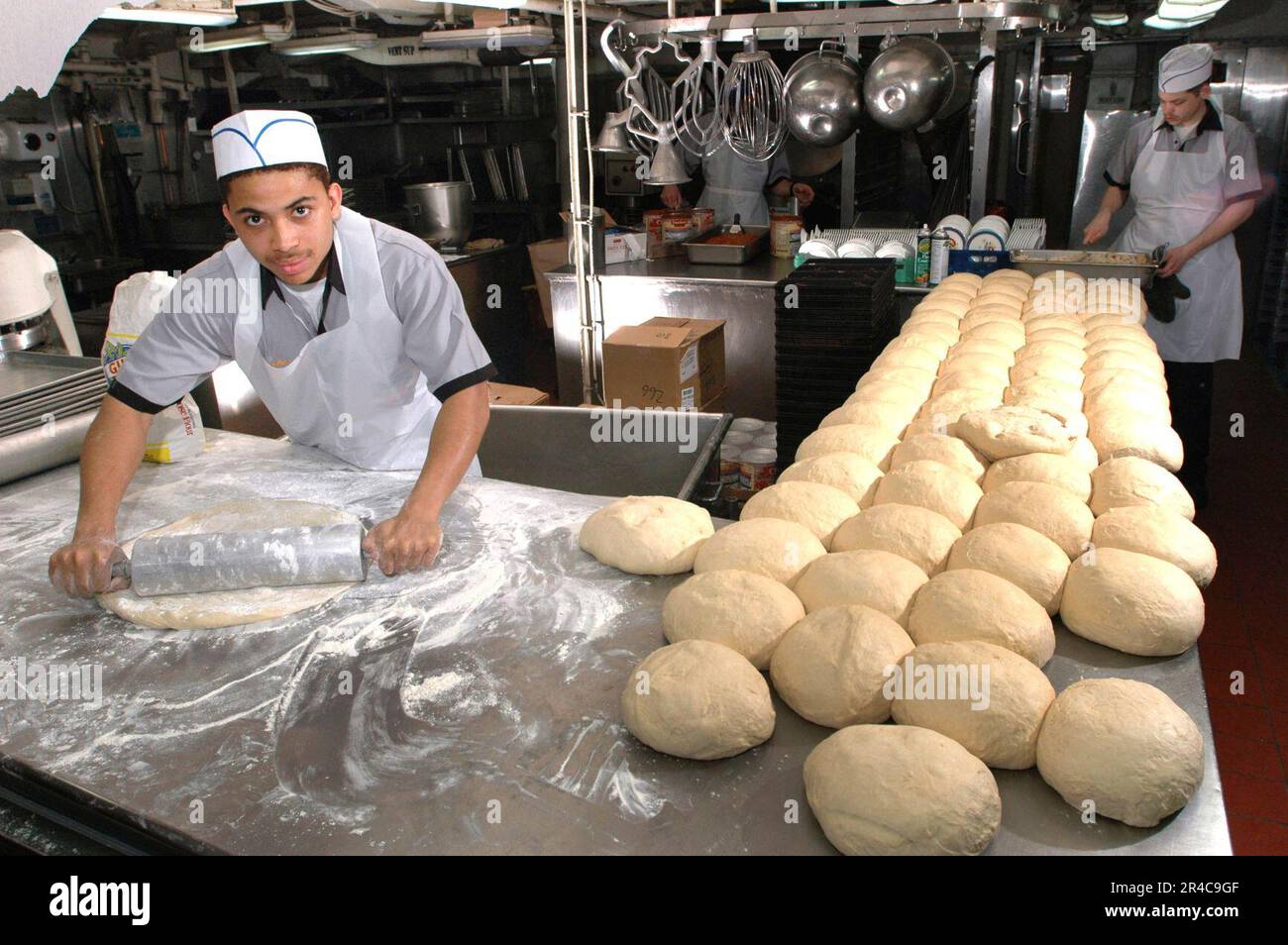US Navy Culinary Specialist Seaman assigned aboard the USS Kitty Hawk ...