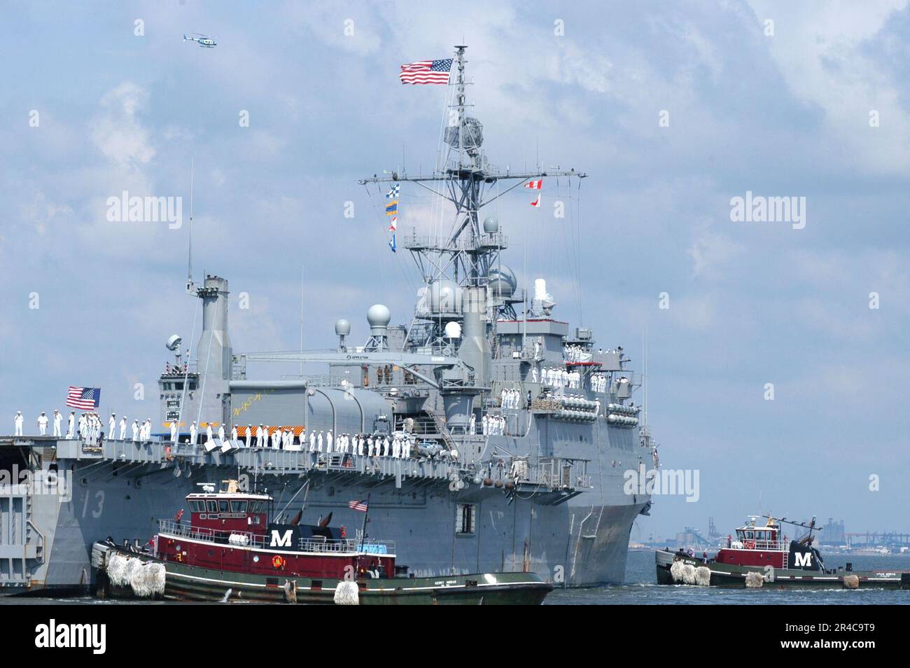 US Navy Tug boats assist the amphibious transport dock USS Nashville ...