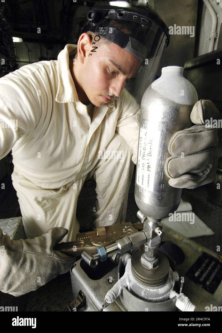US Navy Machinist's Mate Fireman prepares a sample canister of liquid ...