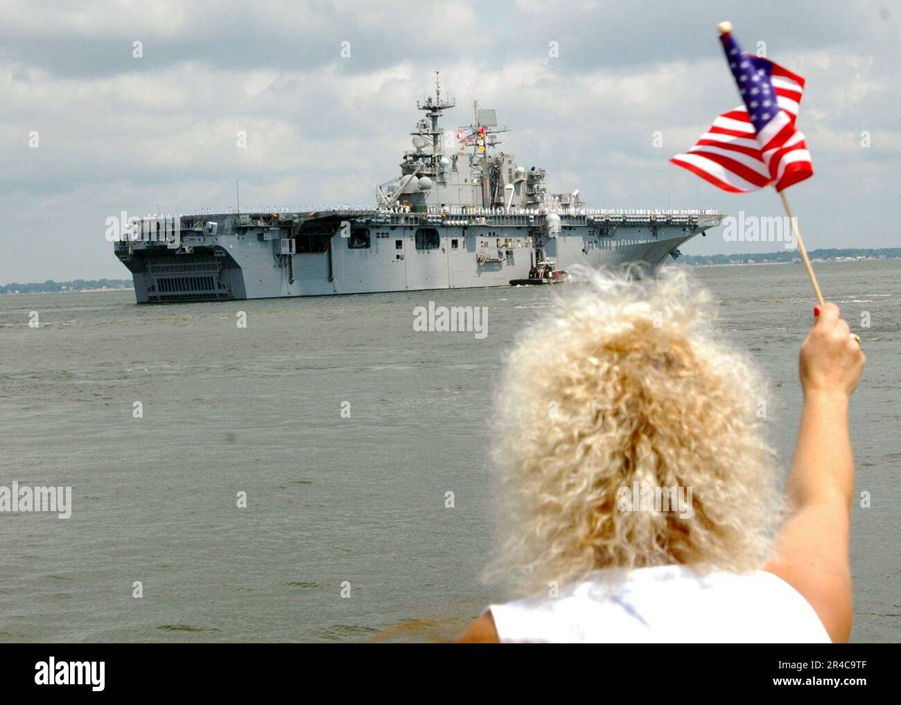 US Navy Families wave goodbye as the Sailors aboard the amphibious ...