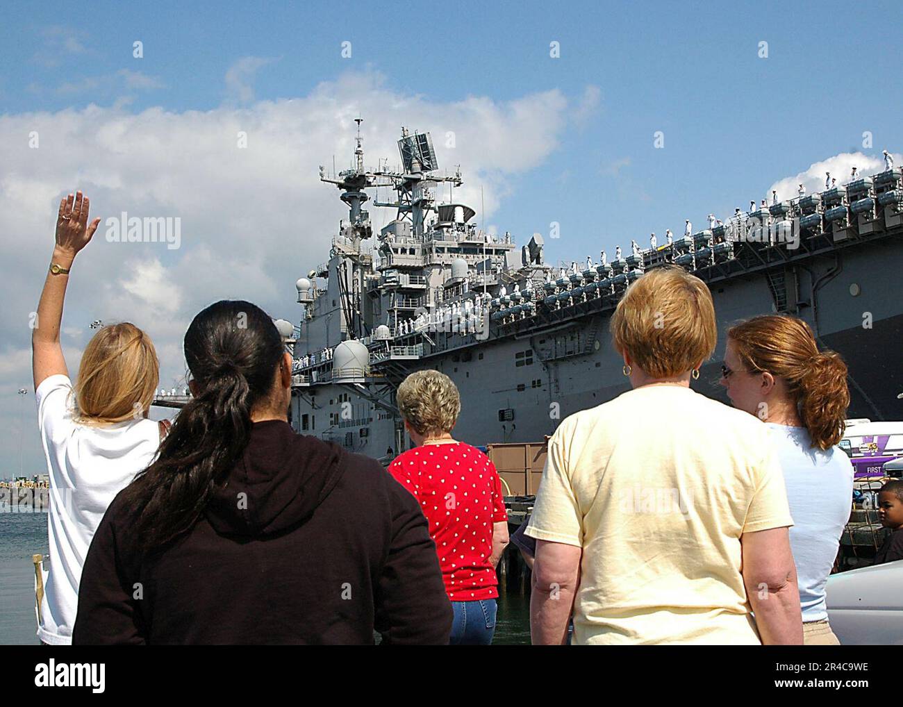 US Navy Families wave goodbye as the Sailors aboard the amphibious ...