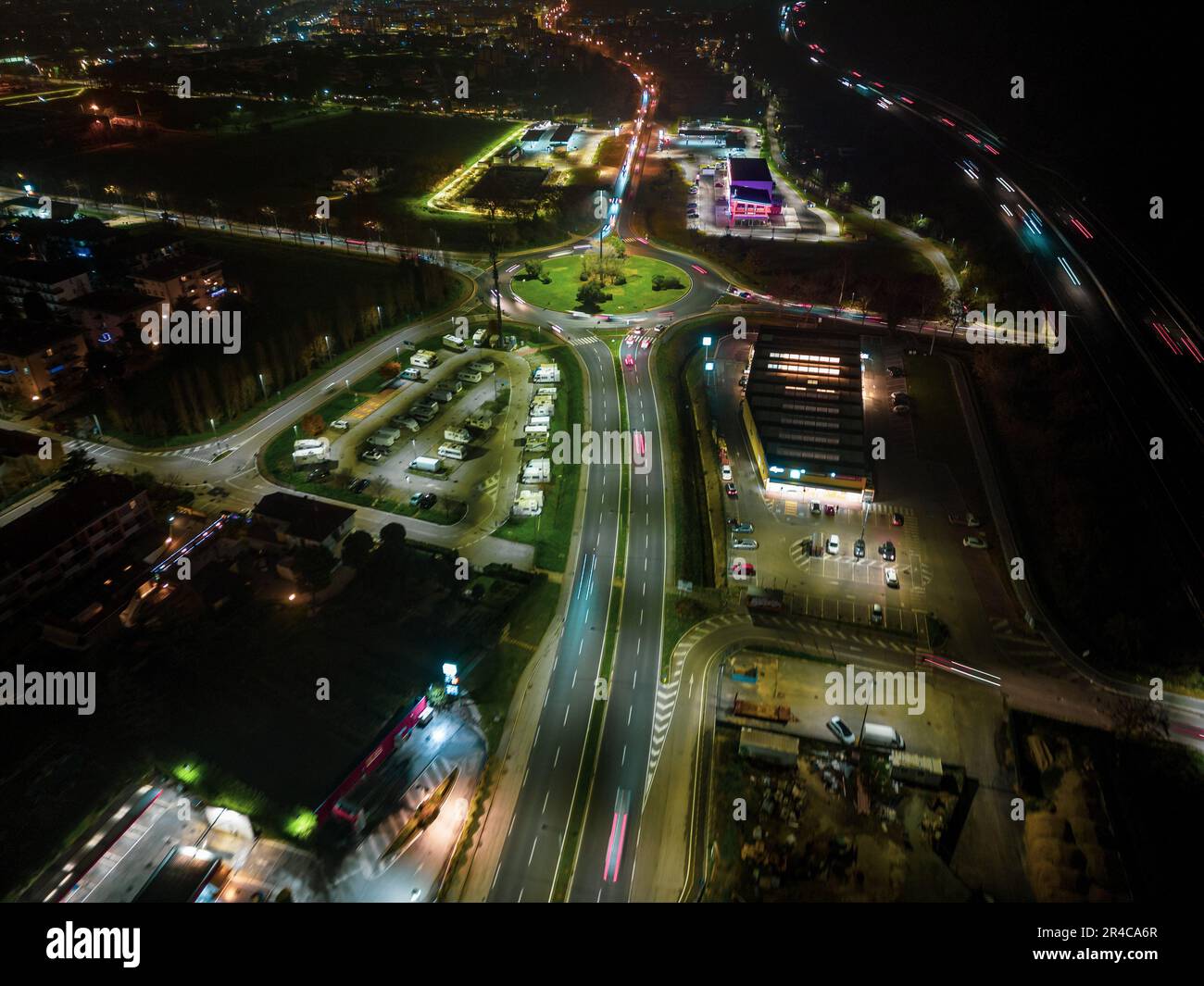 An aerial view of an urban intersection at night, with a busy street ...