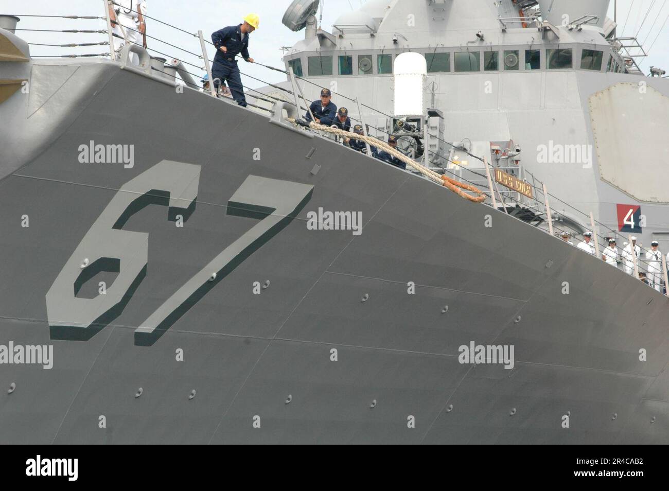 US Navy Sailors aboard USS Cole (DDG 67) haul in mooring lines to get ...