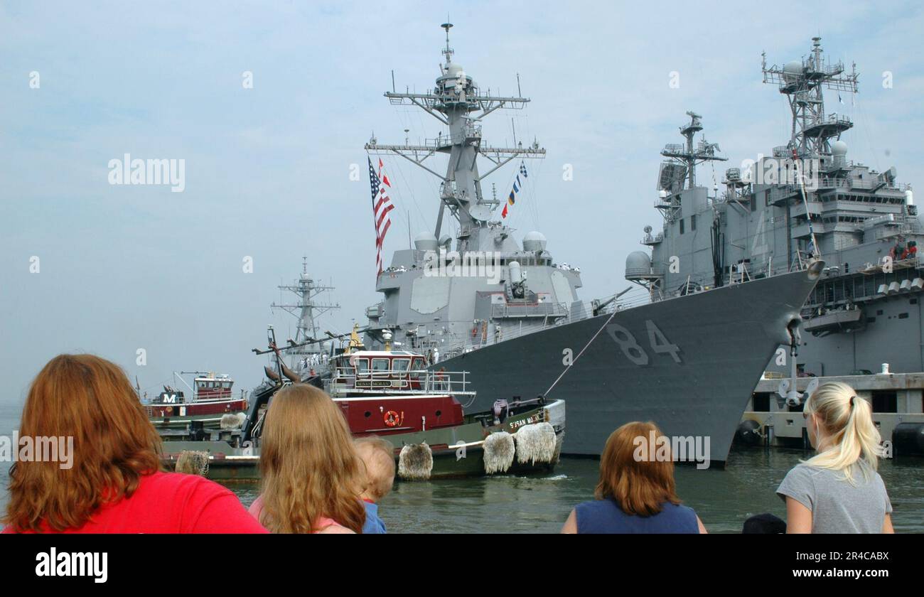 US Navy Family members await the departure of guided-missile destroyer ...