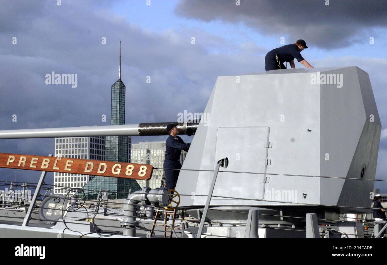 US Navy Gunners Mate 2nd Class clean the five-inch gun aboard the ...