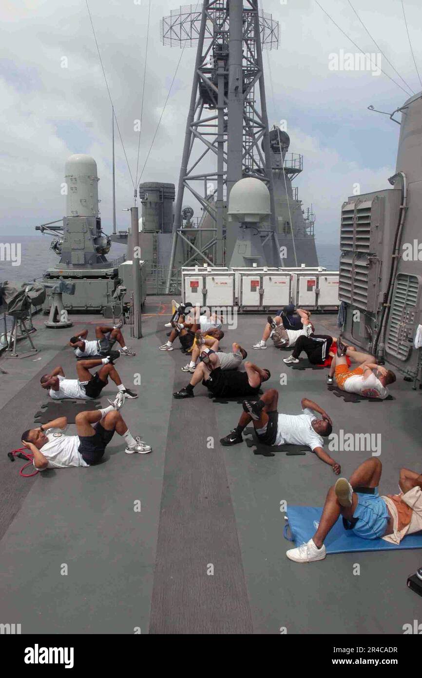 US Navy Sailors perform sit-ups as part of their physical training (PT ...