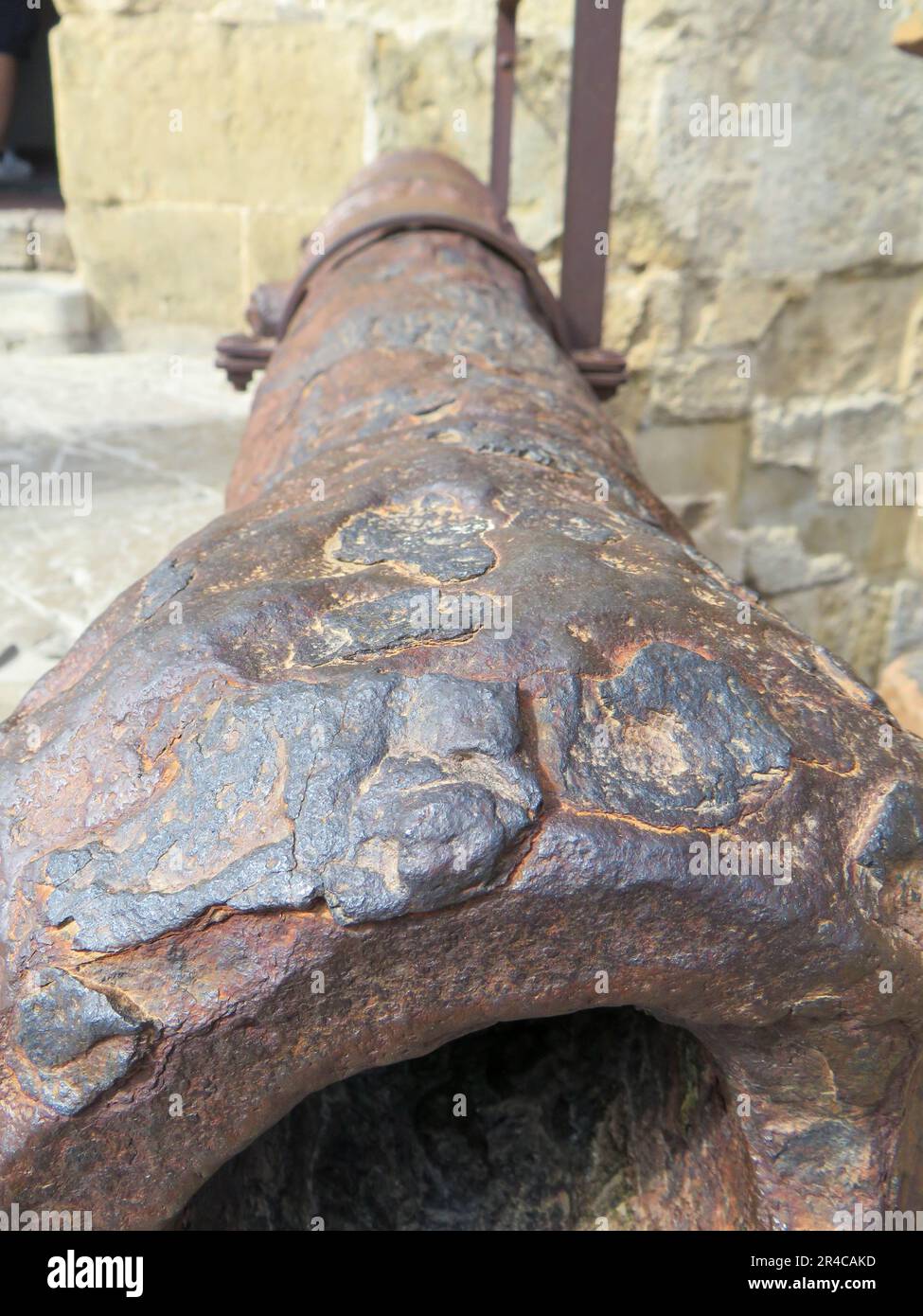 A close-up image of a cannon barrel affixed to the exterior wall of a ...