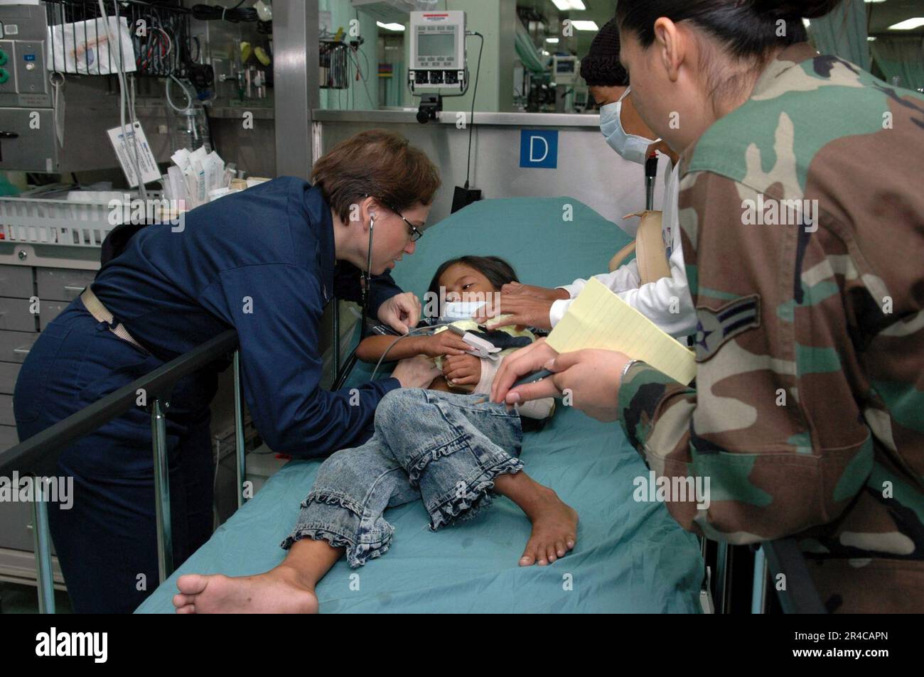 US Navy Navy Lt. checks the vital signs of a child being admitted ...