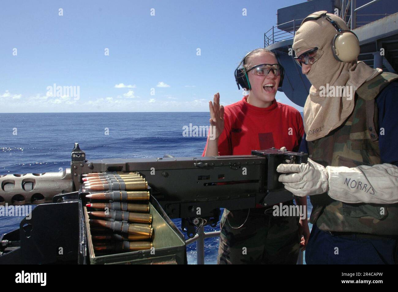 US Navy Gunner's Mate 2nd Class instructs a Sailor assigned to the ...