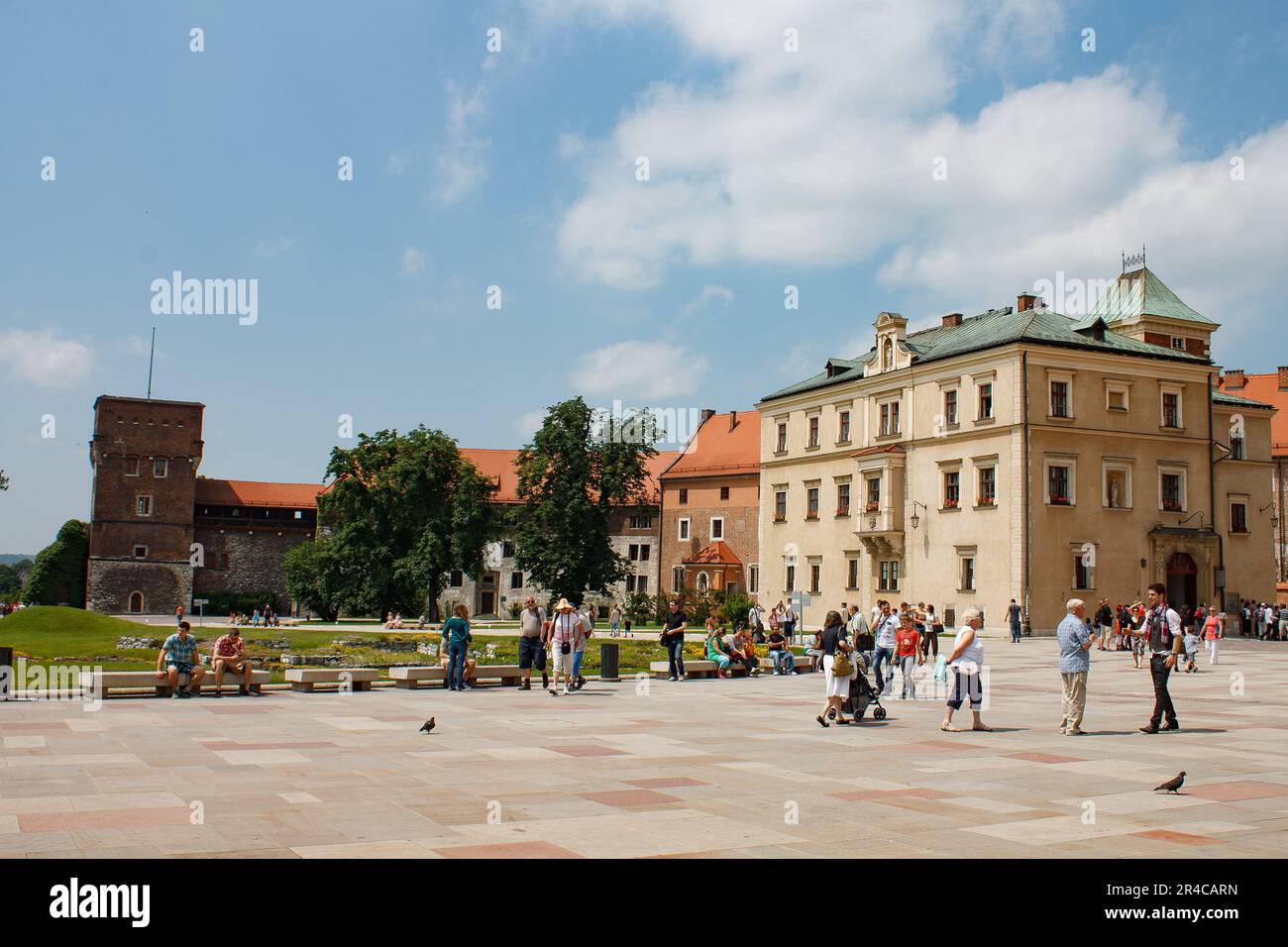 A diverse group of people walking together in a large outdoor courtyard ...