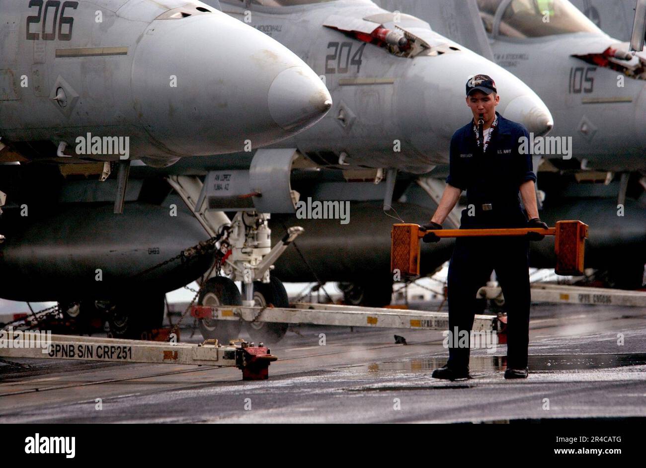 US Navy Acting as the starboard wing safety observer, Airman walks ...