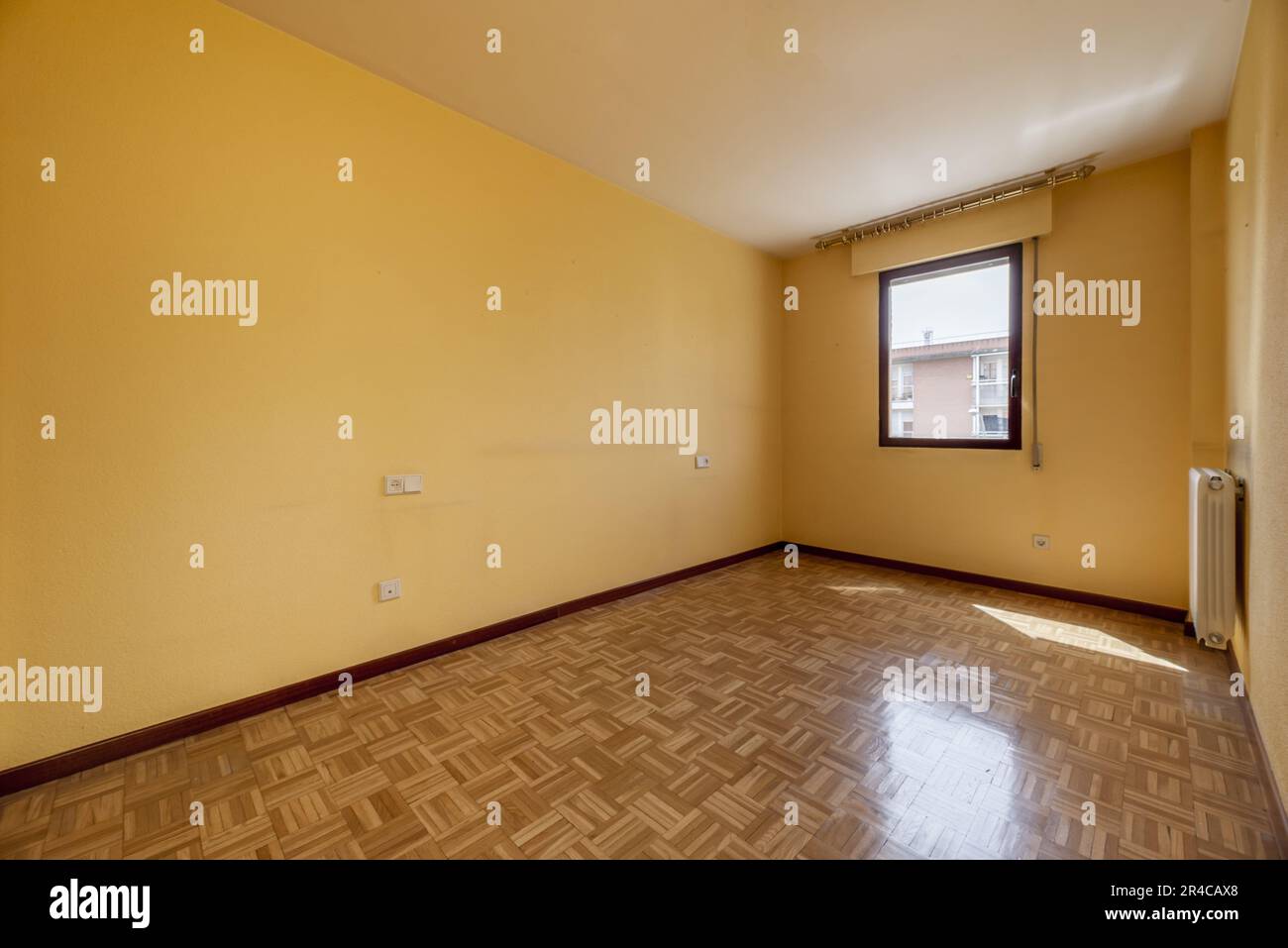 An empty living room with slatted oak parquet flooring, red anodized ...