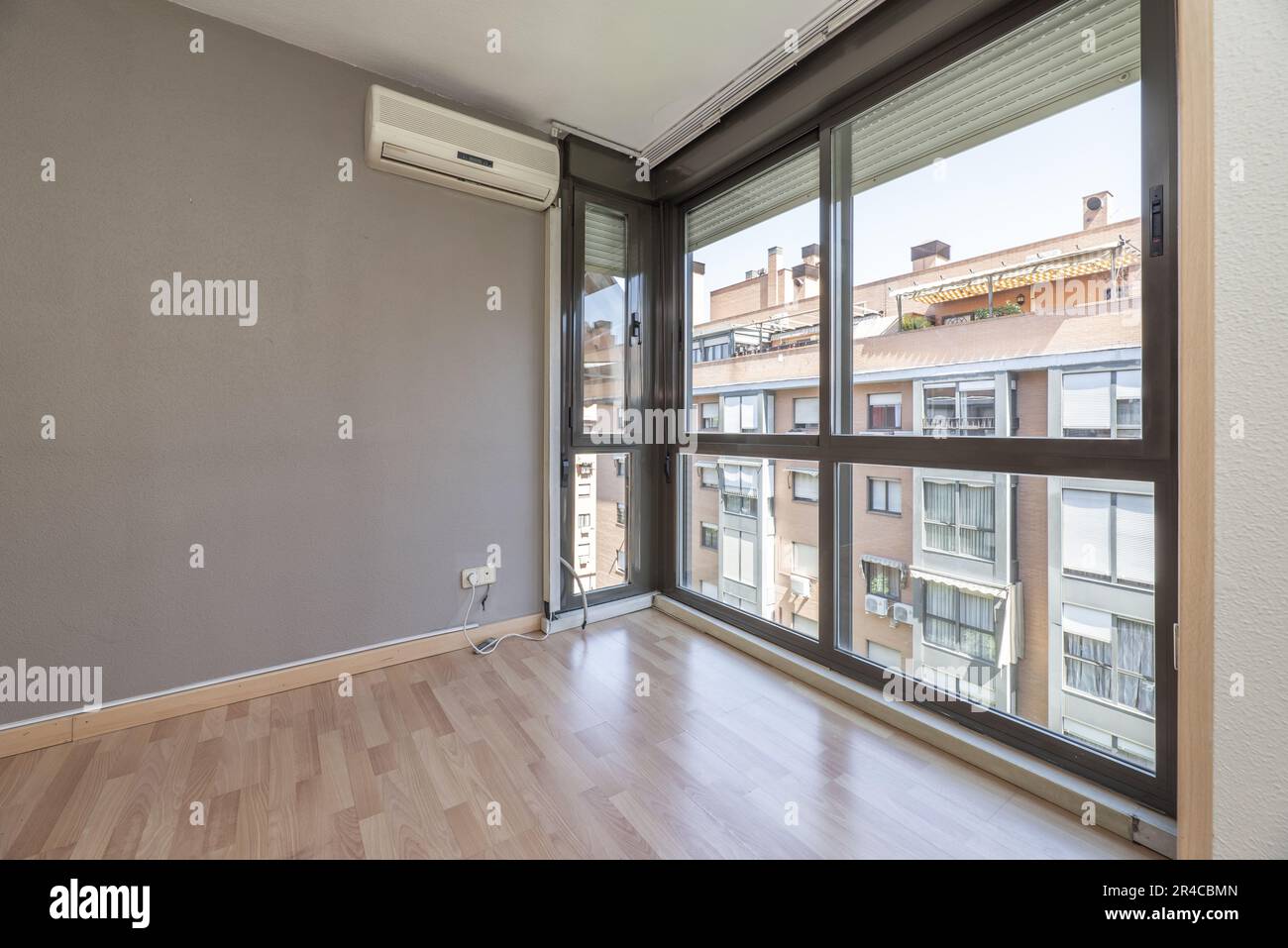 Corner of a room with sliding aluminum windows, air conditioner unit ...