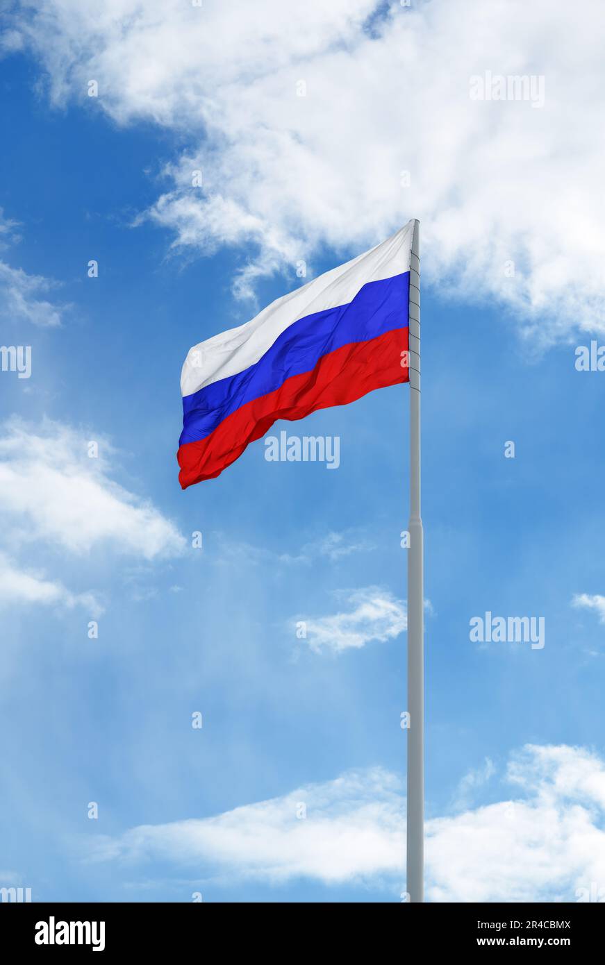 Russian white-blue-red flag is waving in front of blue sky and clouds ...