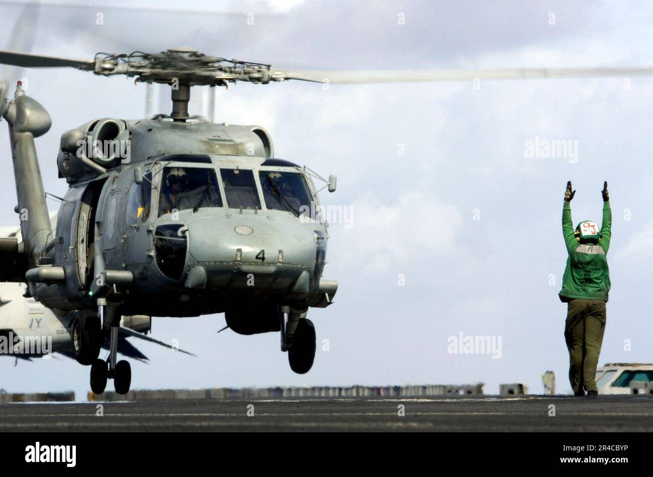 US Navy A landing signalman enlisted (LSE) directs an SH-60F Seahawk assigned to the Black ...