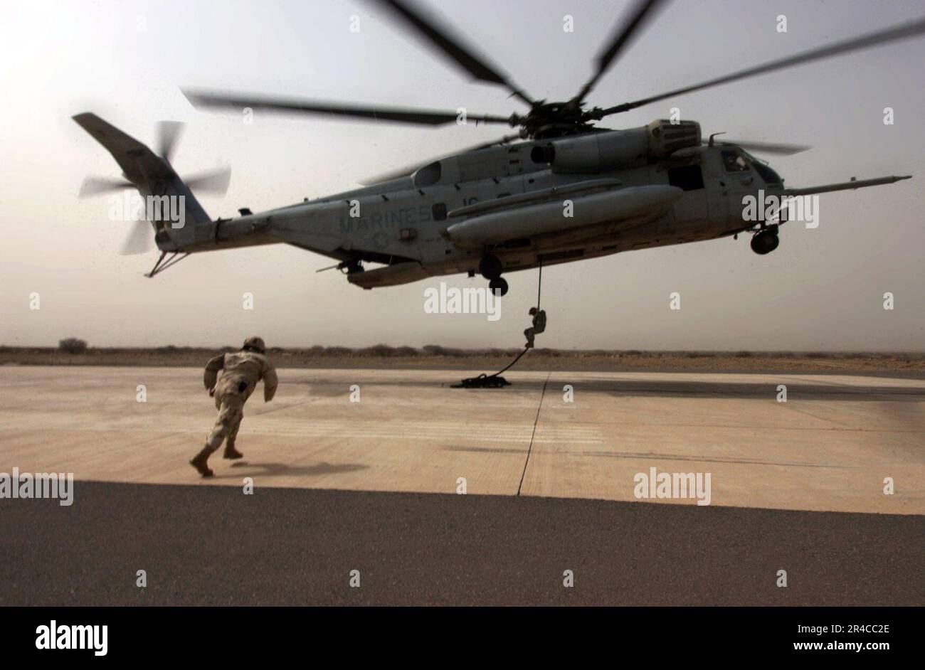 US Navy Staff Sgt. runs against the prop-wash of a U.S. Marine CH-53 ...