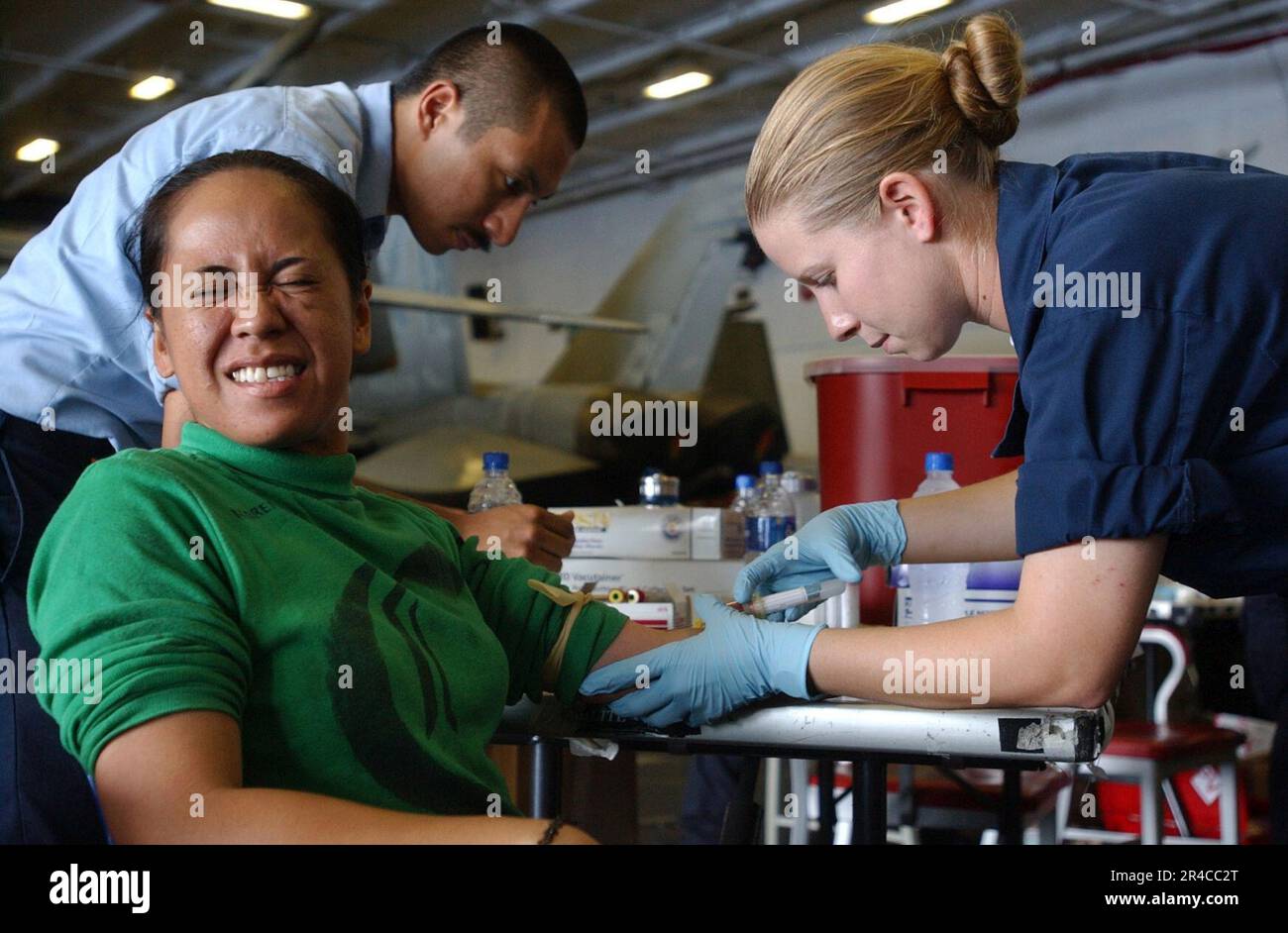 US Navy Hospital Corpsman 2nd Class draws blood from an Air Department ...