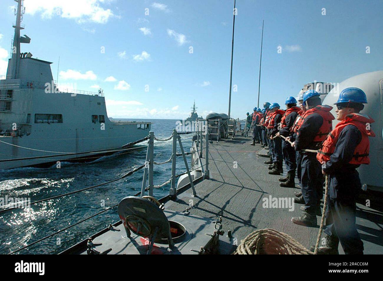 US Navy USS Boone (FFG 28) Sailors handle a line while performing an ...