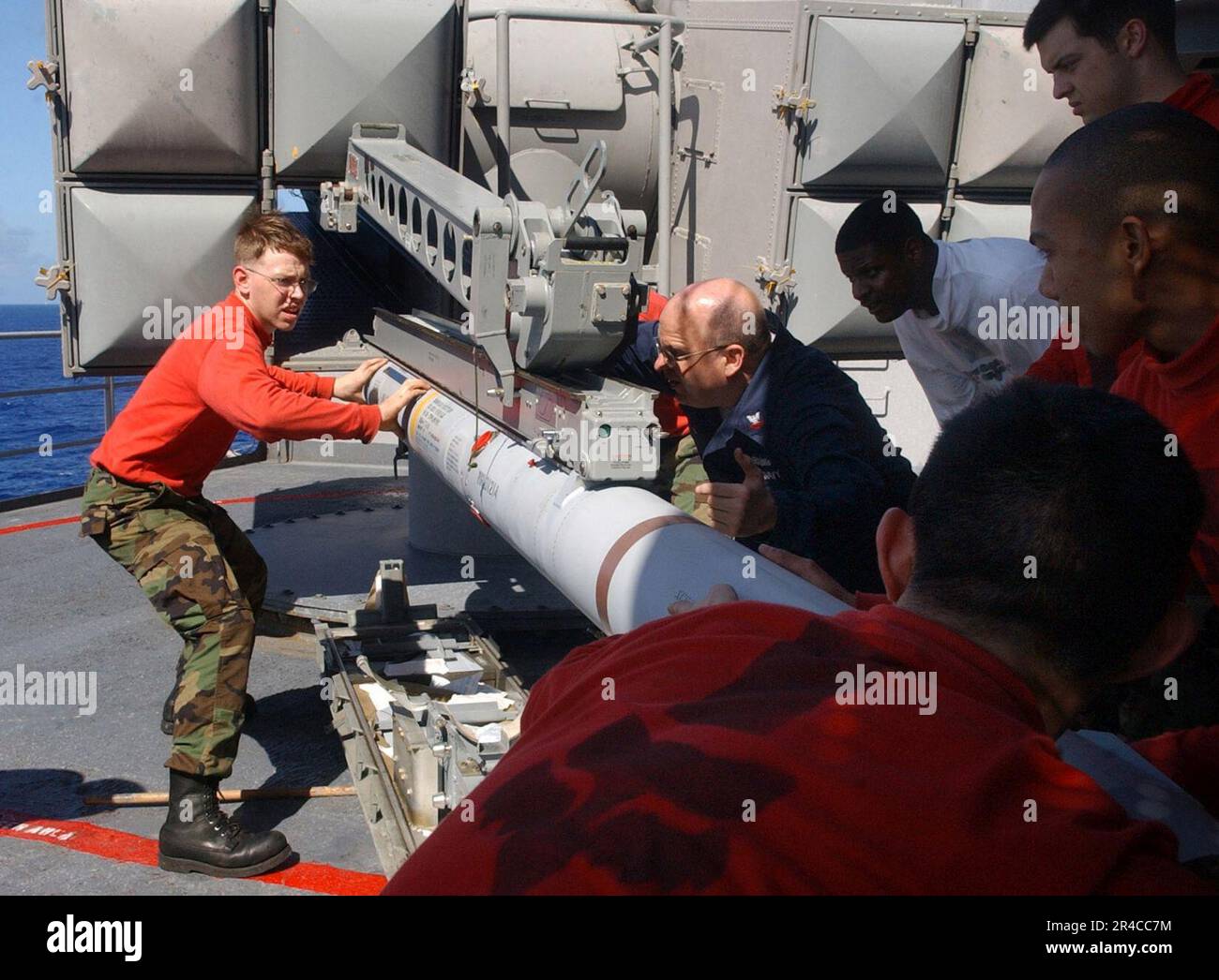 US Navy Fire controlmen brace a NATO Sea Sparrow missile as it is being ...