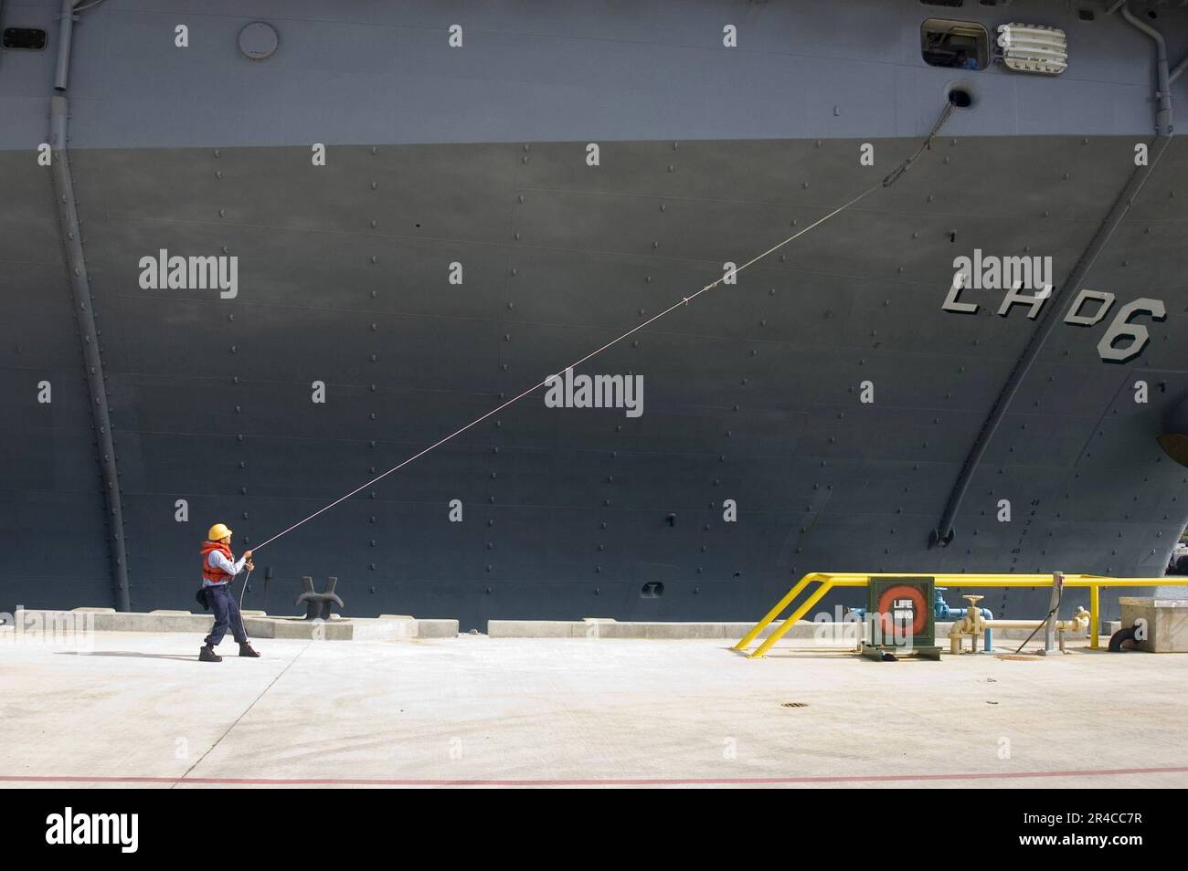 US Navy A line handler secures mooring lines for the amphibious assault ...
