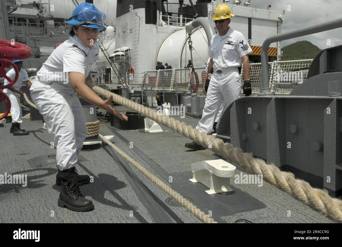 US Navy Seaman heaves in a mooring line as rescue and salvage ship USS ...