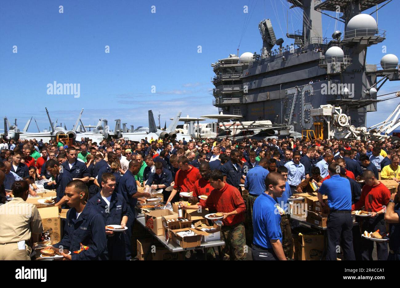 US Navy Sailors swarm food tables on the flight deck of USS Ronald ...