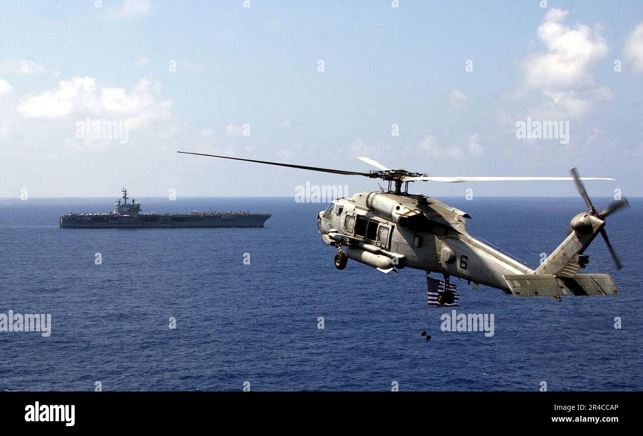 US Navy With the National Ensign flying, an HH-60H Seahawk assigned to ...