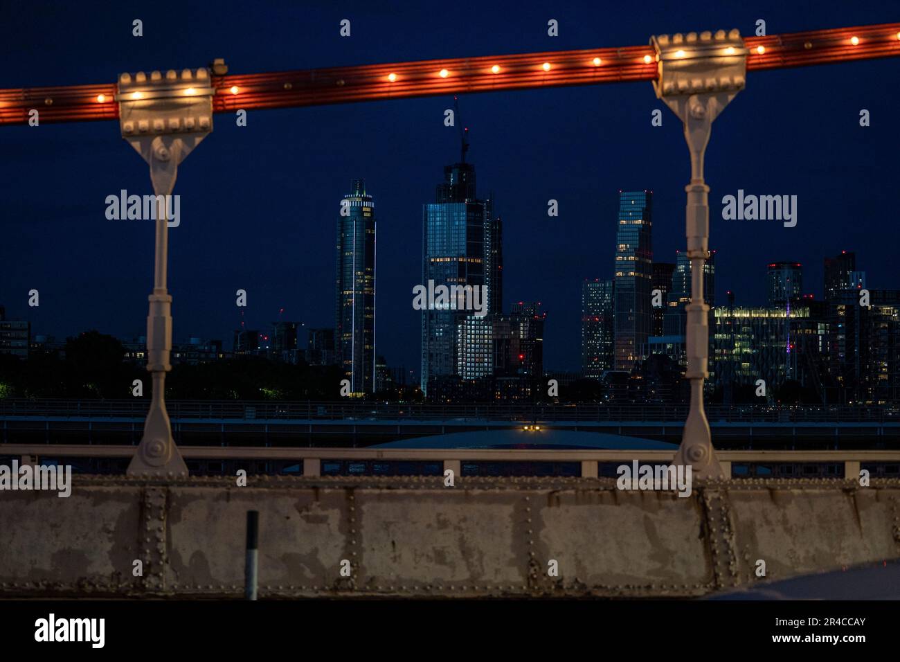 Illuminated bridge at night, surrounded by a busy cityscape with ...