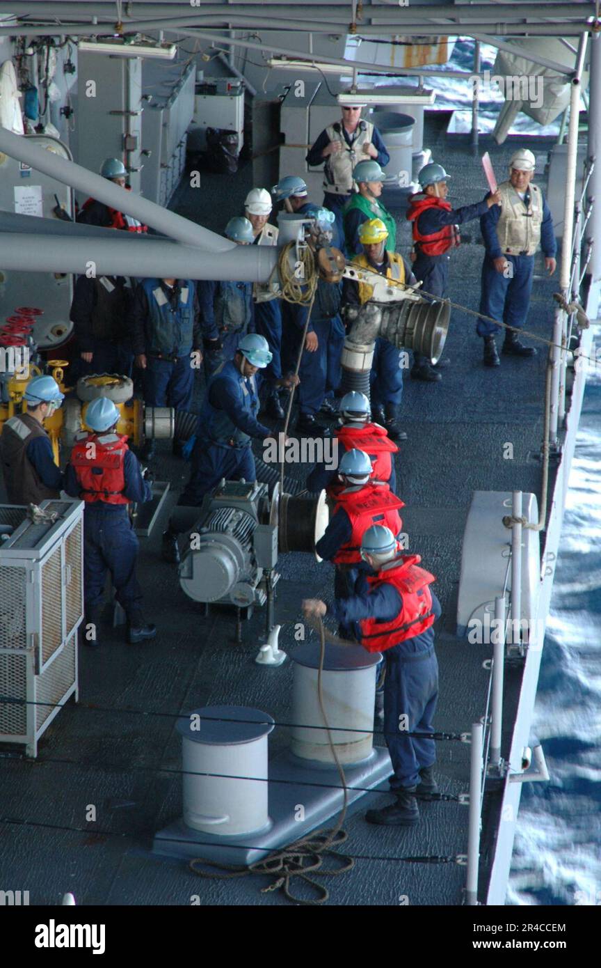 US Navy Deck Department Sailors secure a line on a sponson aboard USS ...