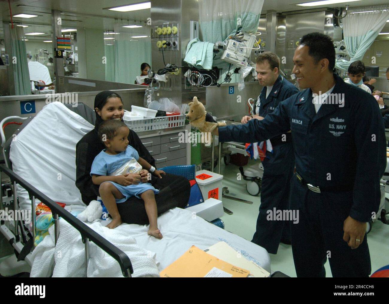 US Navy Navy Hospital Corpsman 3rd Class entertains a young patient ...