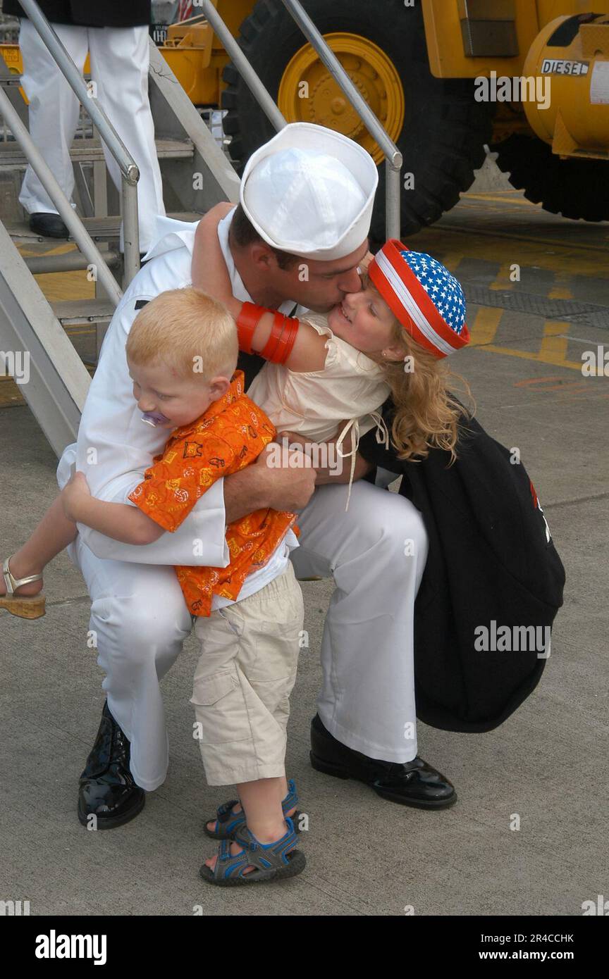 US Navy Interior Communications Electrician 2nd Class hugs his children ...